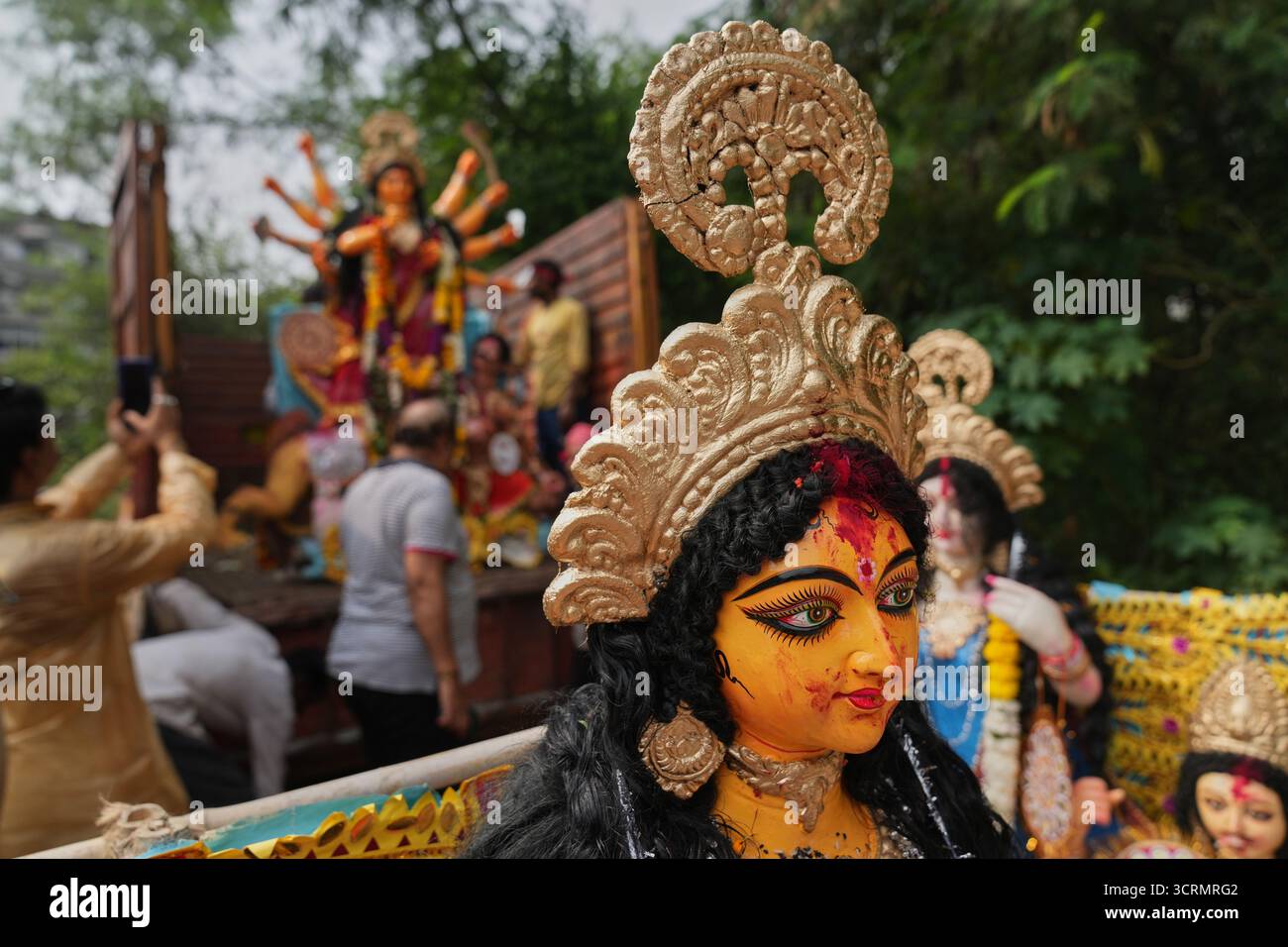 Devotees prepare to immerse an idol of Hindu goddess Durga in a ...