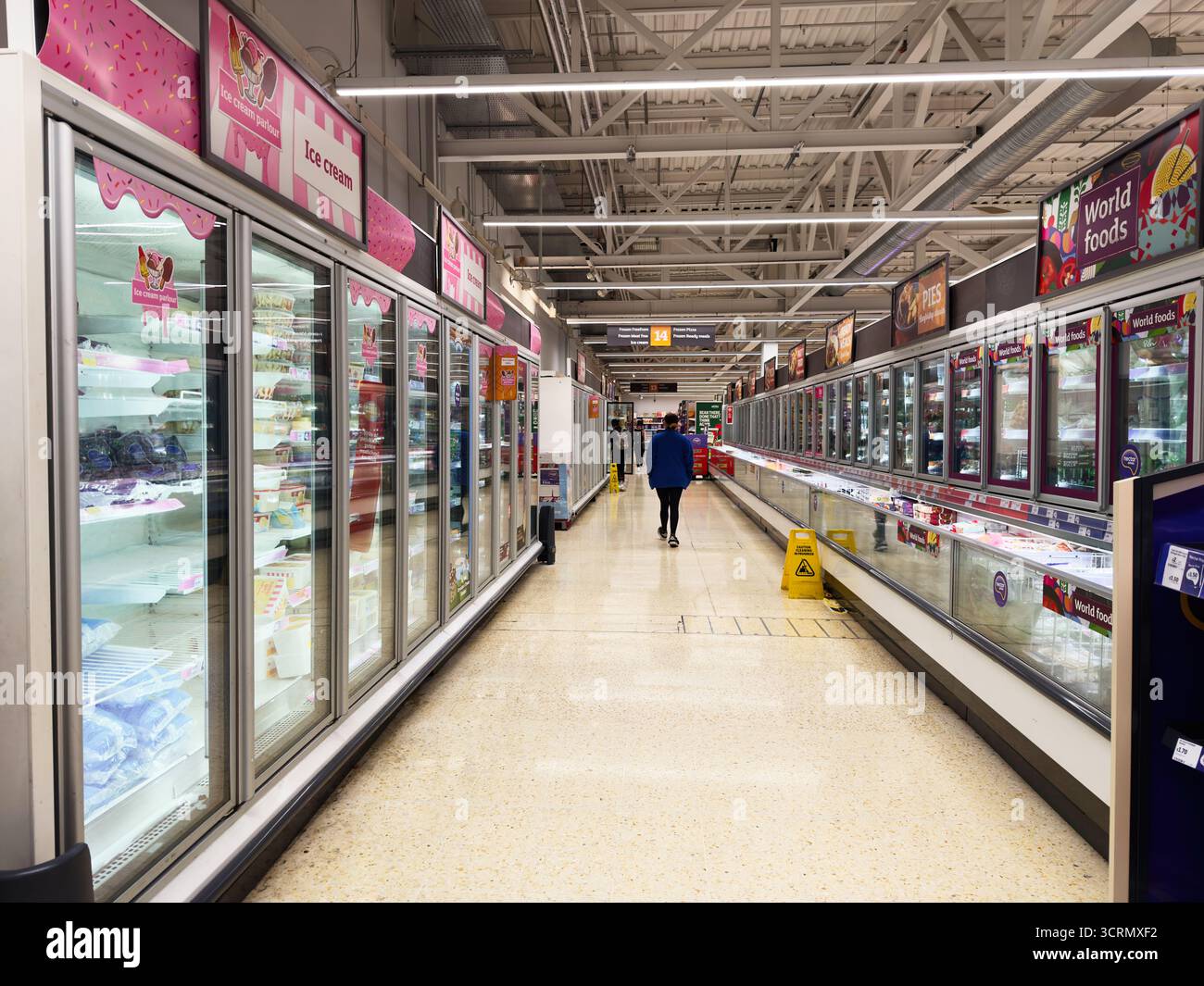 Salford, UK - September 25, 2025: A lone shopper walks down a bright ...