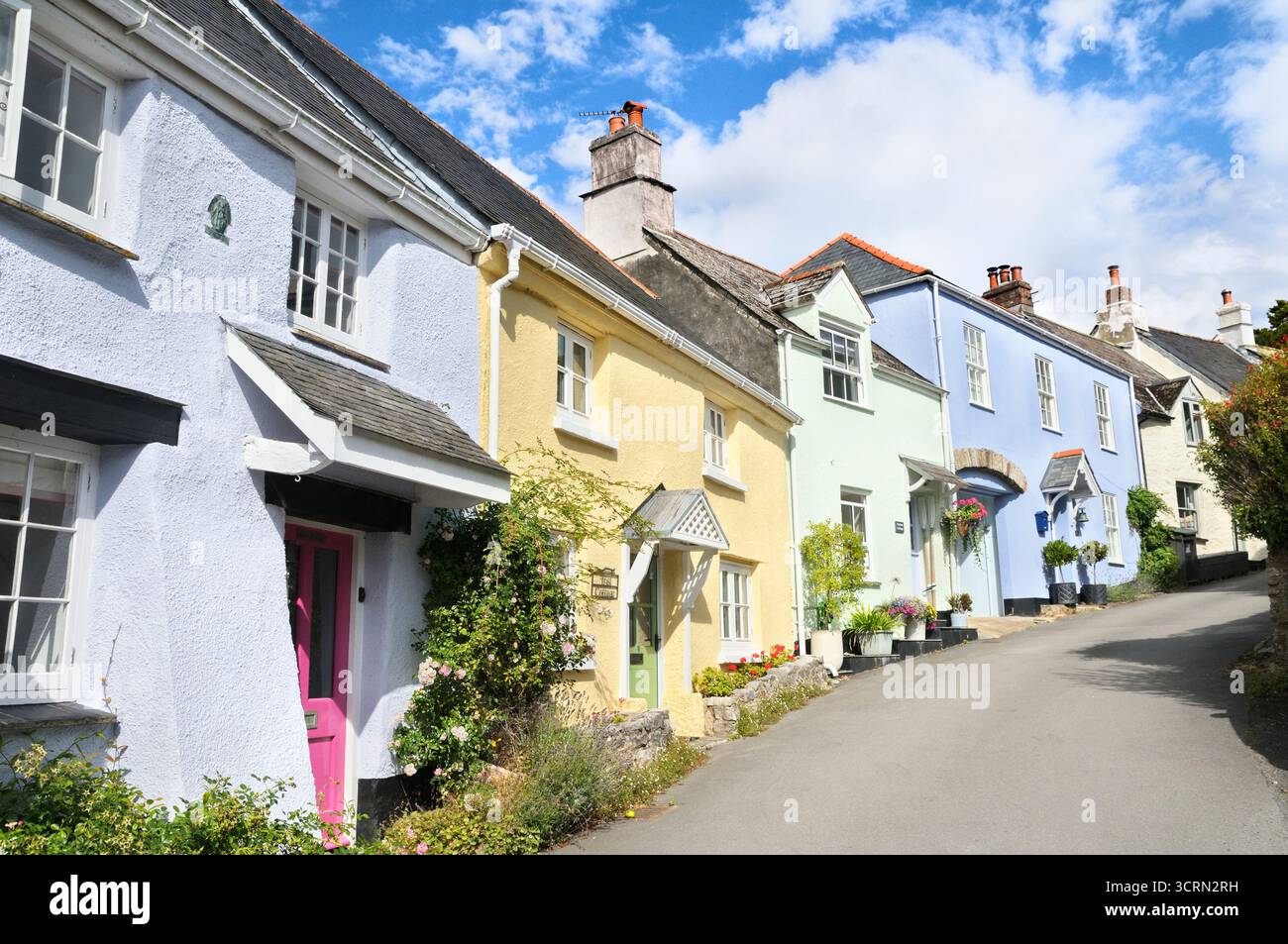 Traditional English country cottages in pastel colours on a gentle hill ...