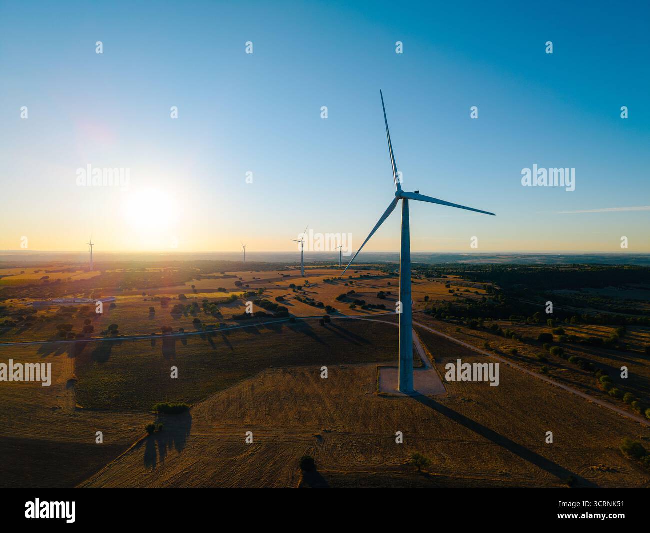 Drone photo of a wind turbine in Spain at dawn, with the sun rising ...