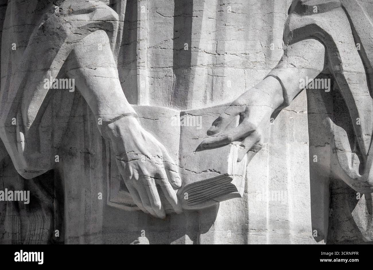 Statue of Jean Calvin, close-up of his hands holding the Bible, carved ...