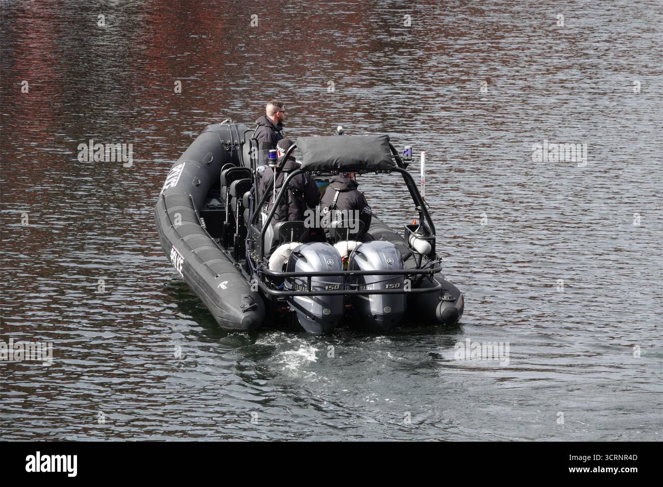Police officers patrol the water in a black rigid inflatable boat (RIB ...