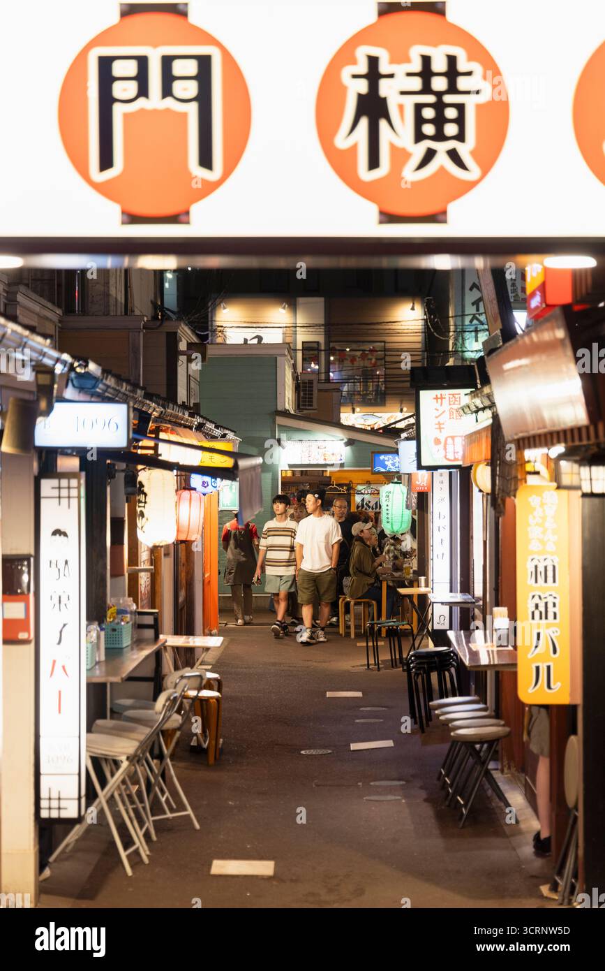 People eating at restaurants in yokocho alley, Hakodate, Hokkaido ...
