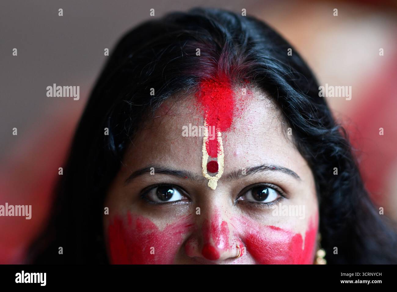 A Hindu devotee receives a vermillion mark on her forehead during the ...