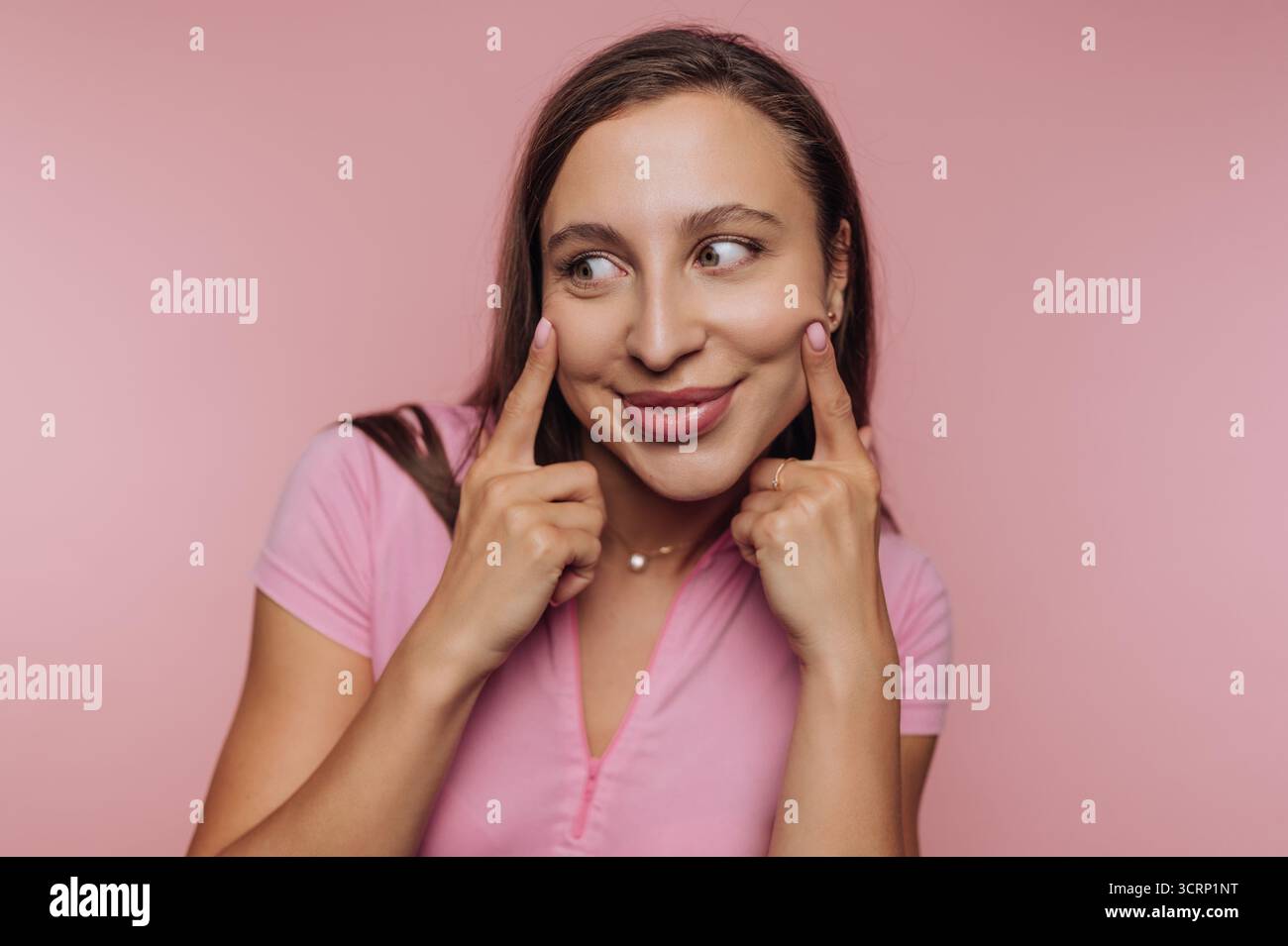 Woman points fingers cheeks hi-res stock photography and images - Alamy
