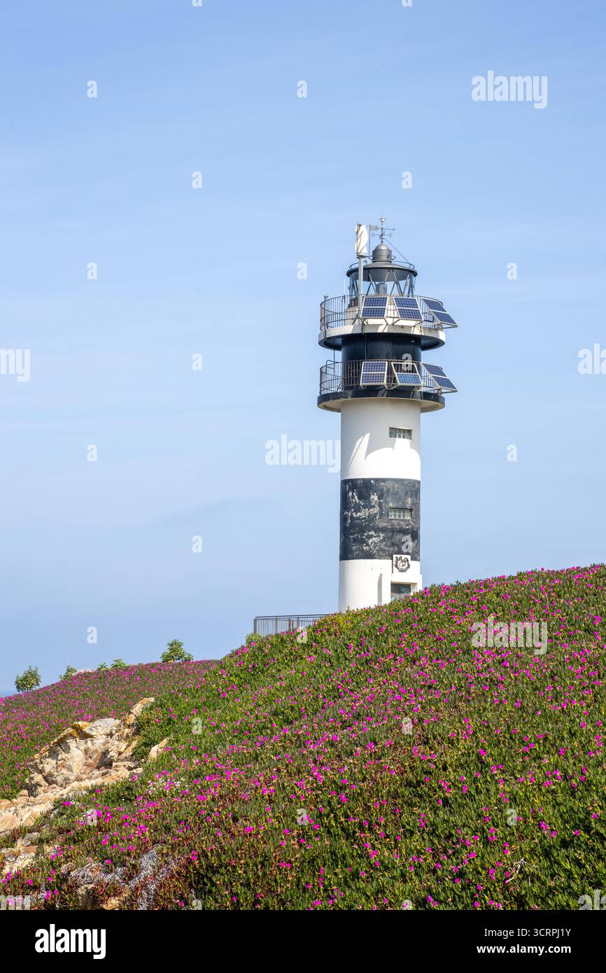 Isla Pancha lighthouse surrounded by rugged cliffs and Atlantic waters ...