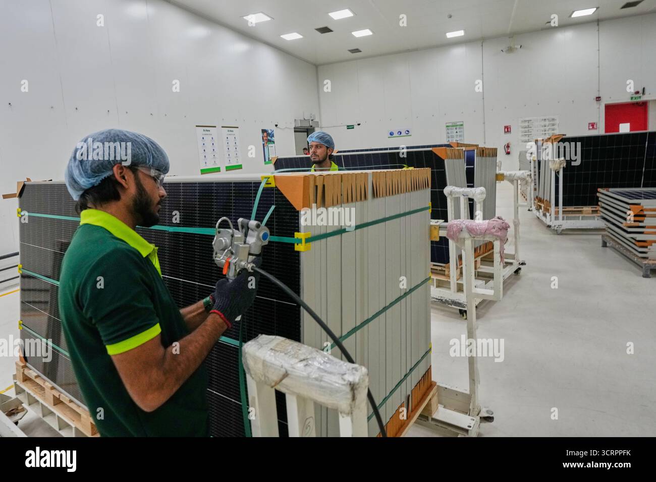 Workers tie finished solar panels for final packing at the ReNew solar ...