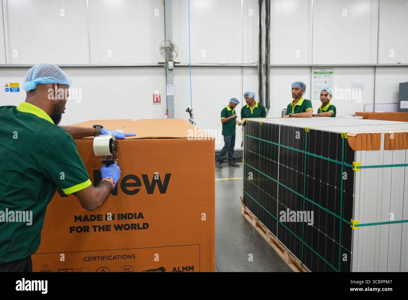 Workers pack solar panels at the ReNew solar panels manufacturing plant ...