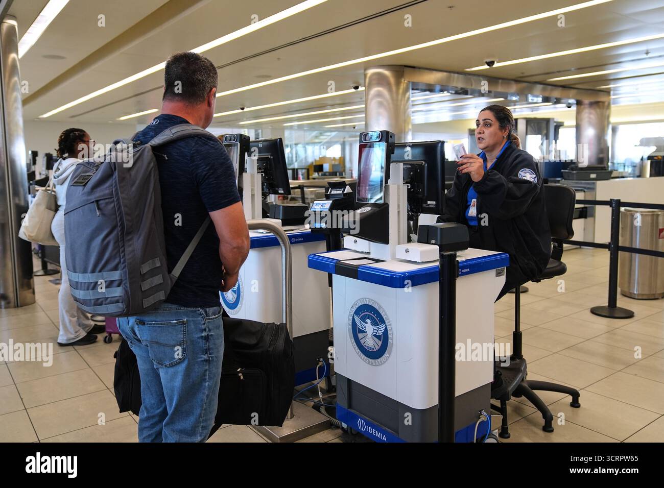 A Transportation Security Administration worker, right, checks ...