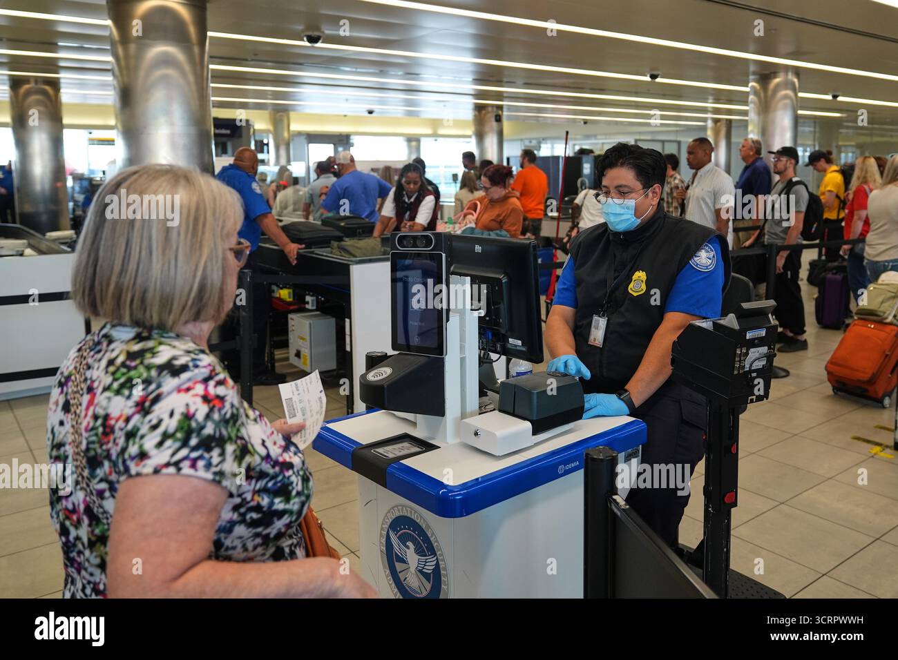 A Transportation Security Administration worker, right, works at a ...