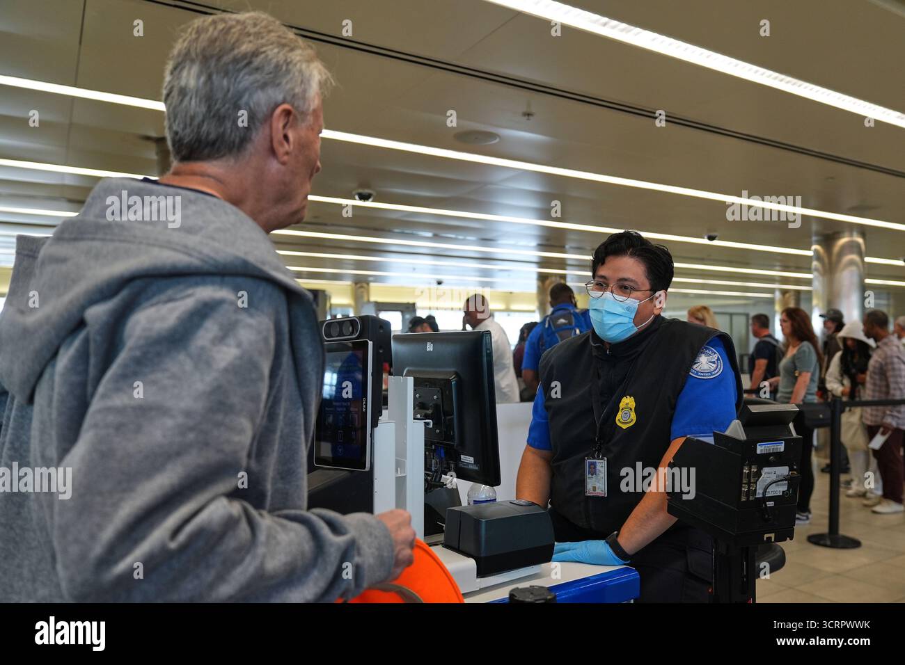 A Transportation Security Administration worker, right, works at a ...