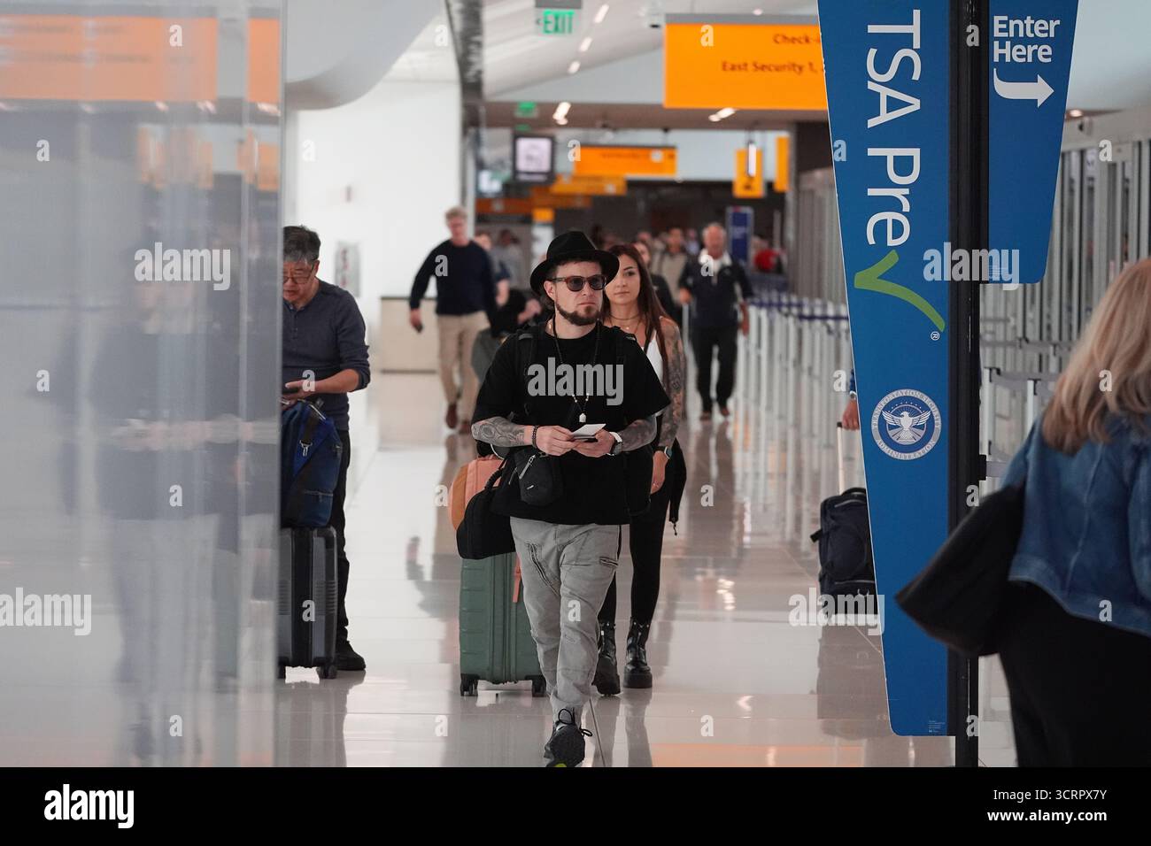 Travelers enter a security checkpoint operated by the Transportation ...