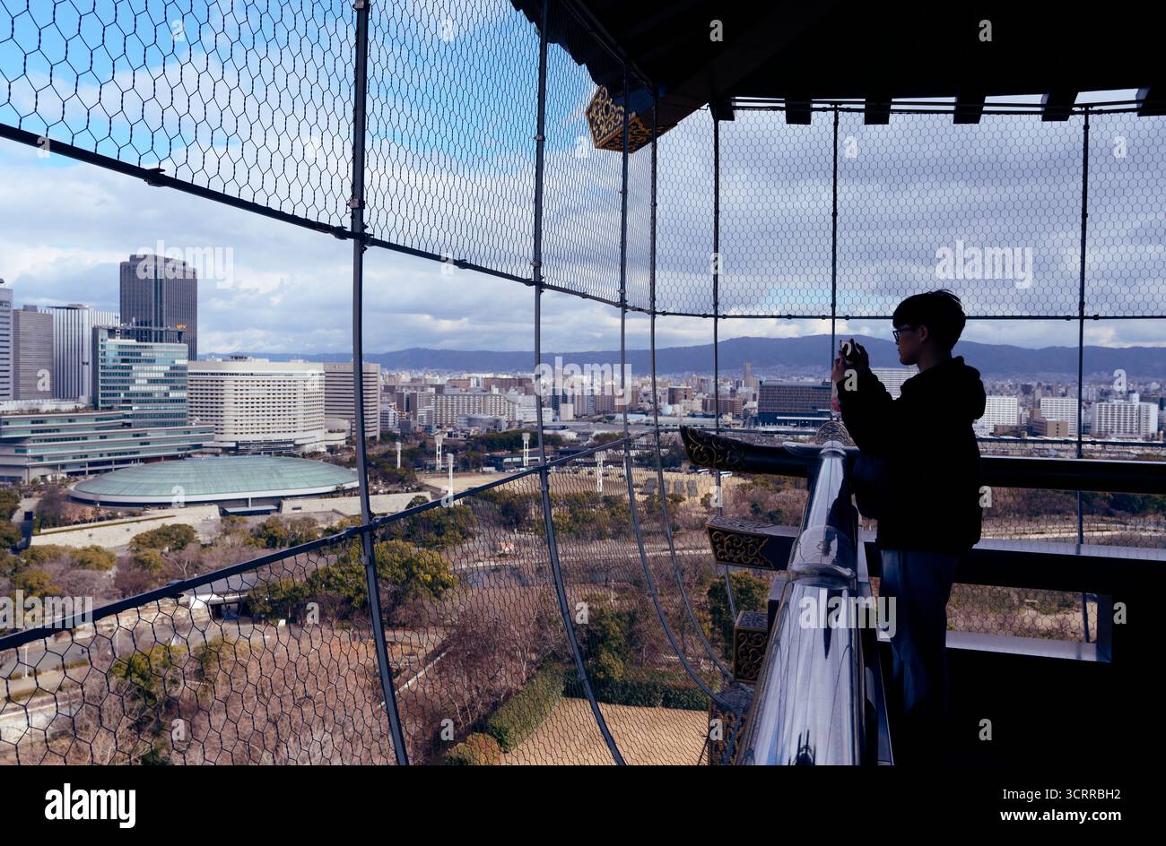 Visitor capturing the city from Osaka Castle’s top observation deck in ...
