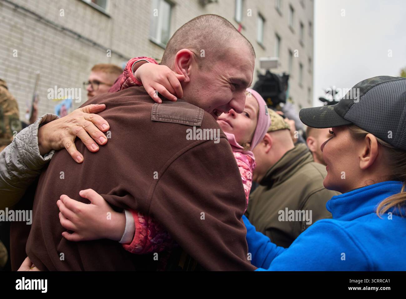 A soldier returning from Russian captivity hugs his child during a POW ...