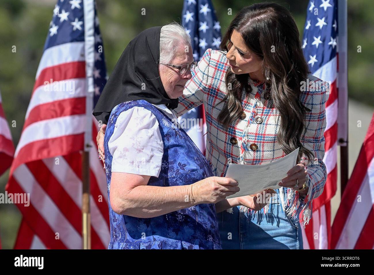 U.S. Secretary of Homeland Security Kristi Noem, right, hands Sarah ...