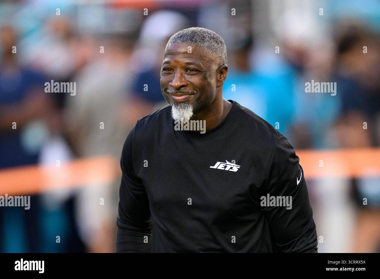 New York Jets head coach Aaron Glenn smiles on the field before an NFL ...