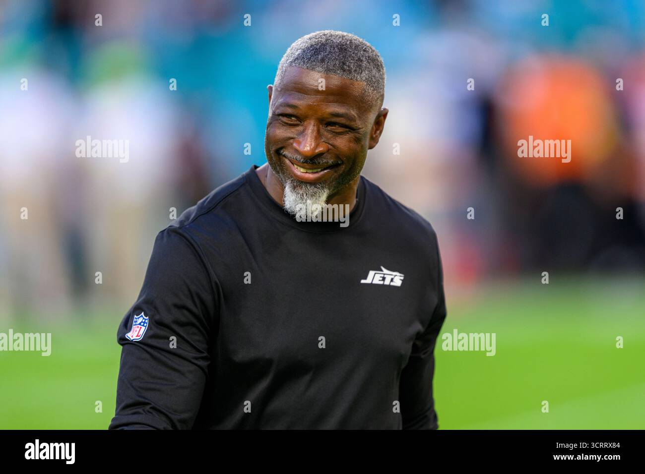 New York Jets head coach Aaron Glenn smiles on the field before an NFL ...