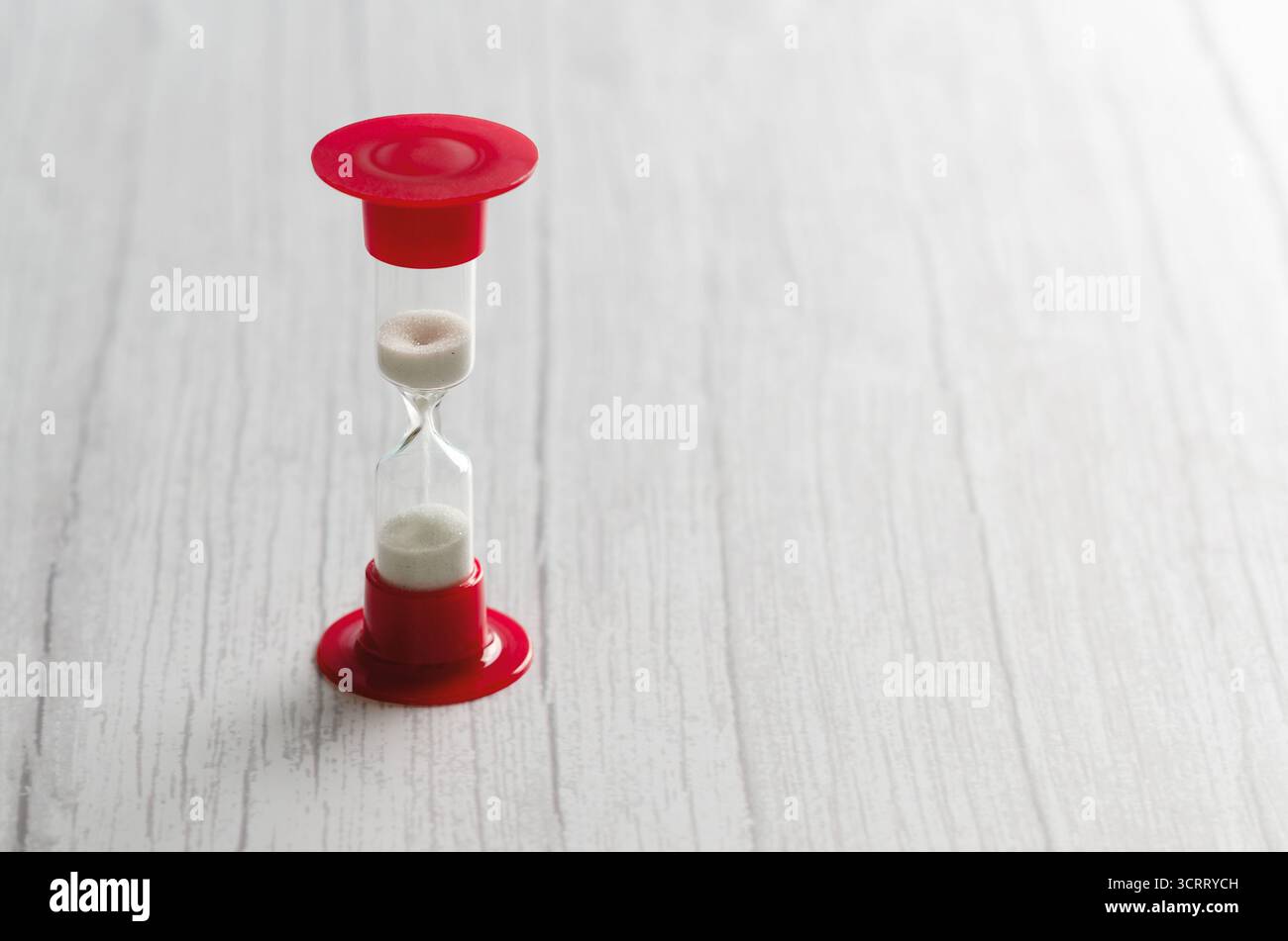 White sand running through the bulbs of an hourglass measuring the ...