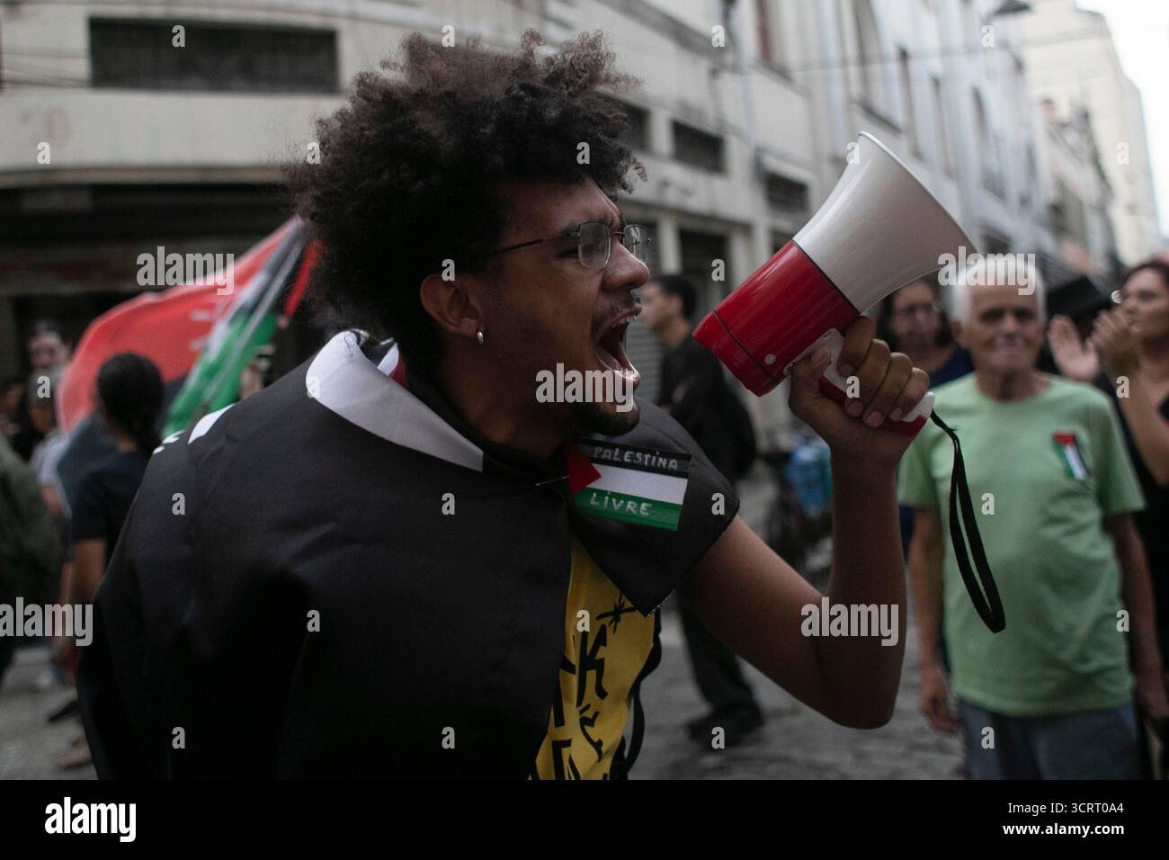 A student speaks into a megaphone during a demonstration in solidarity ...