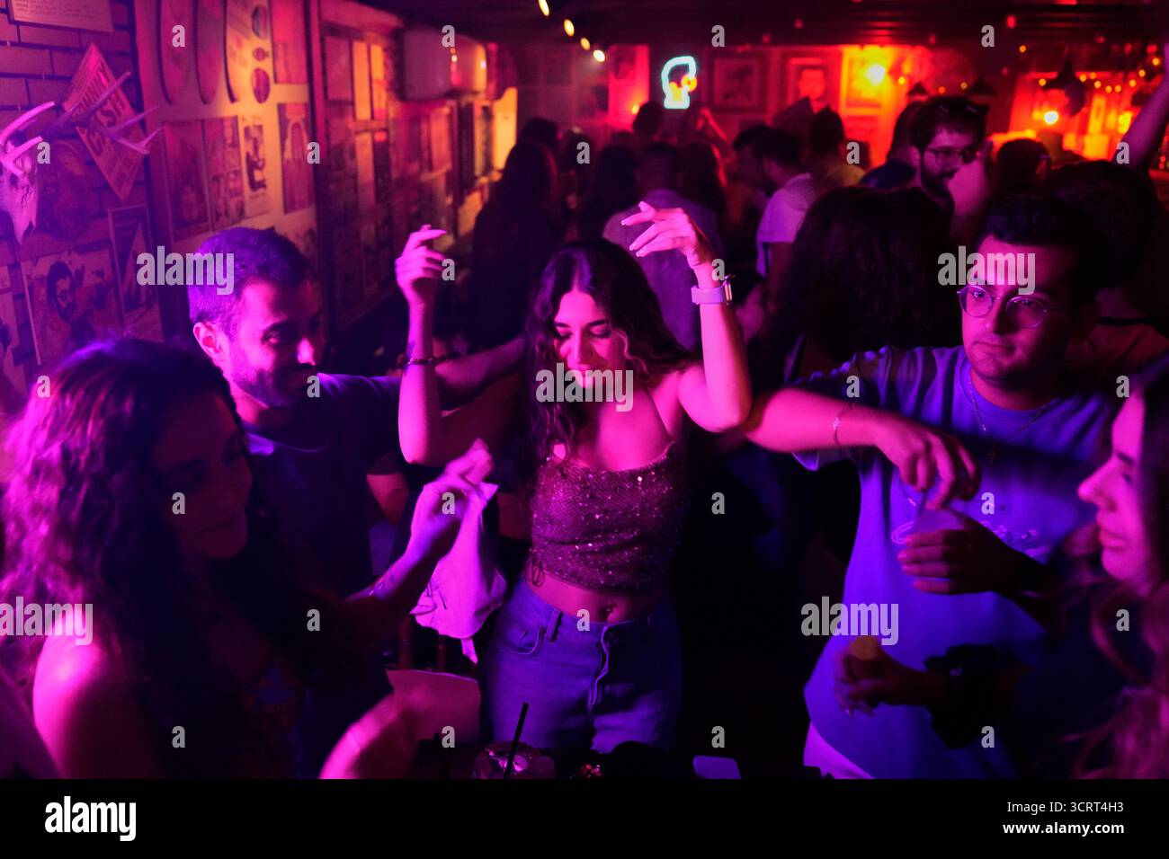 People dance at a bar as they enjoy the first night of the weekend in ...