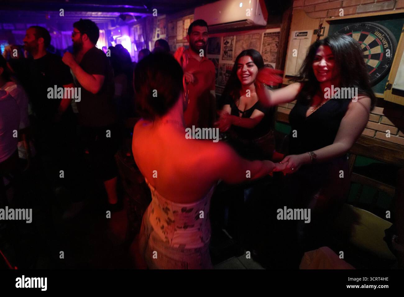 People dance at a bar as they enjoy the first night of the weekend in Damascus, Syria, early ...