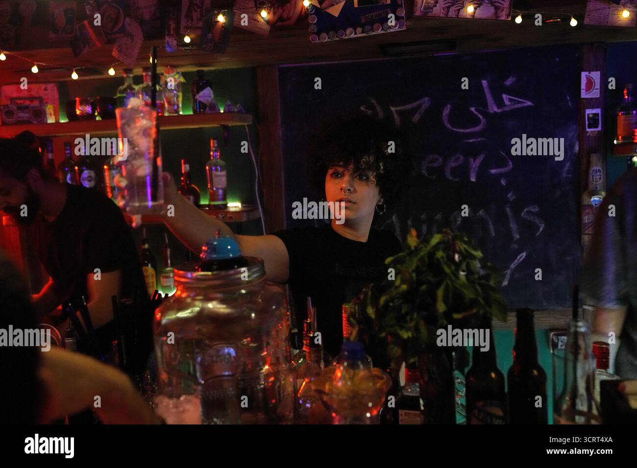 A bartender holds a drink at a bar in Damascus Syria, early Friday, Oct ...