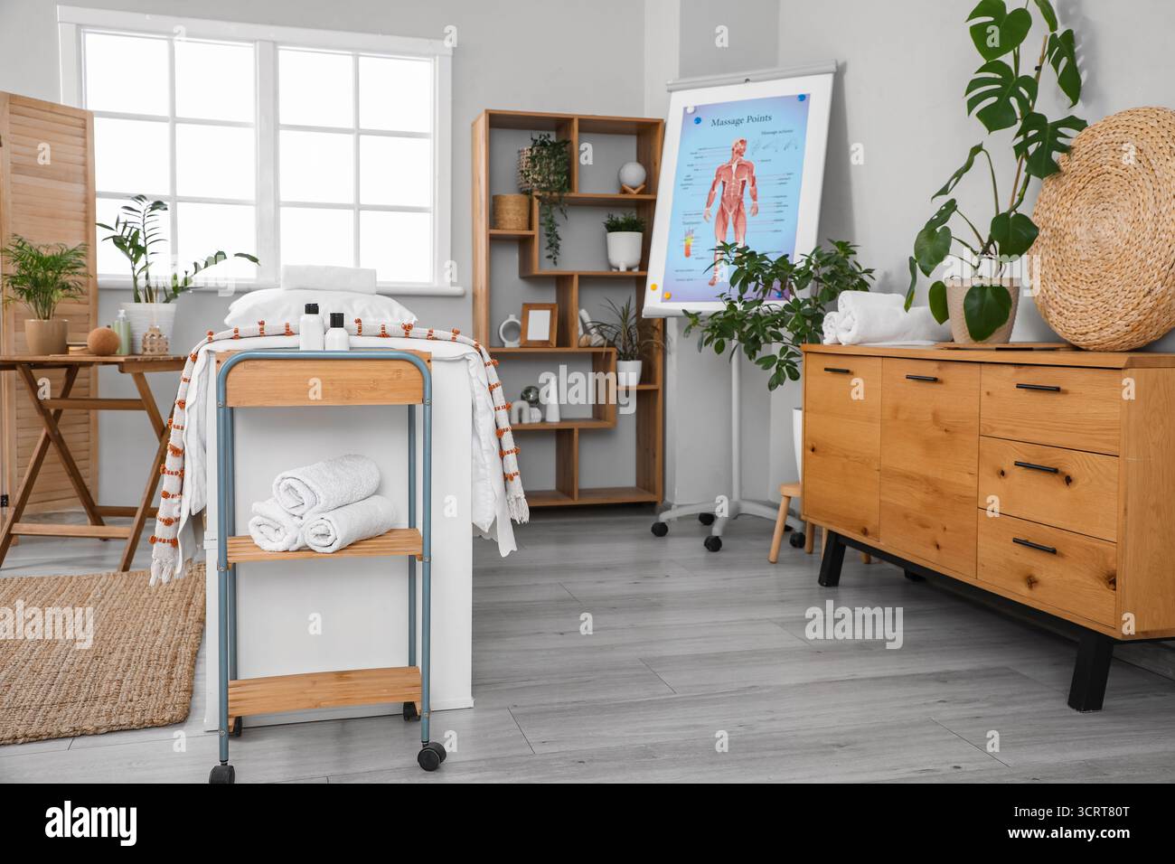 Interior of massage therapist's office with couch, shelving units and ...
