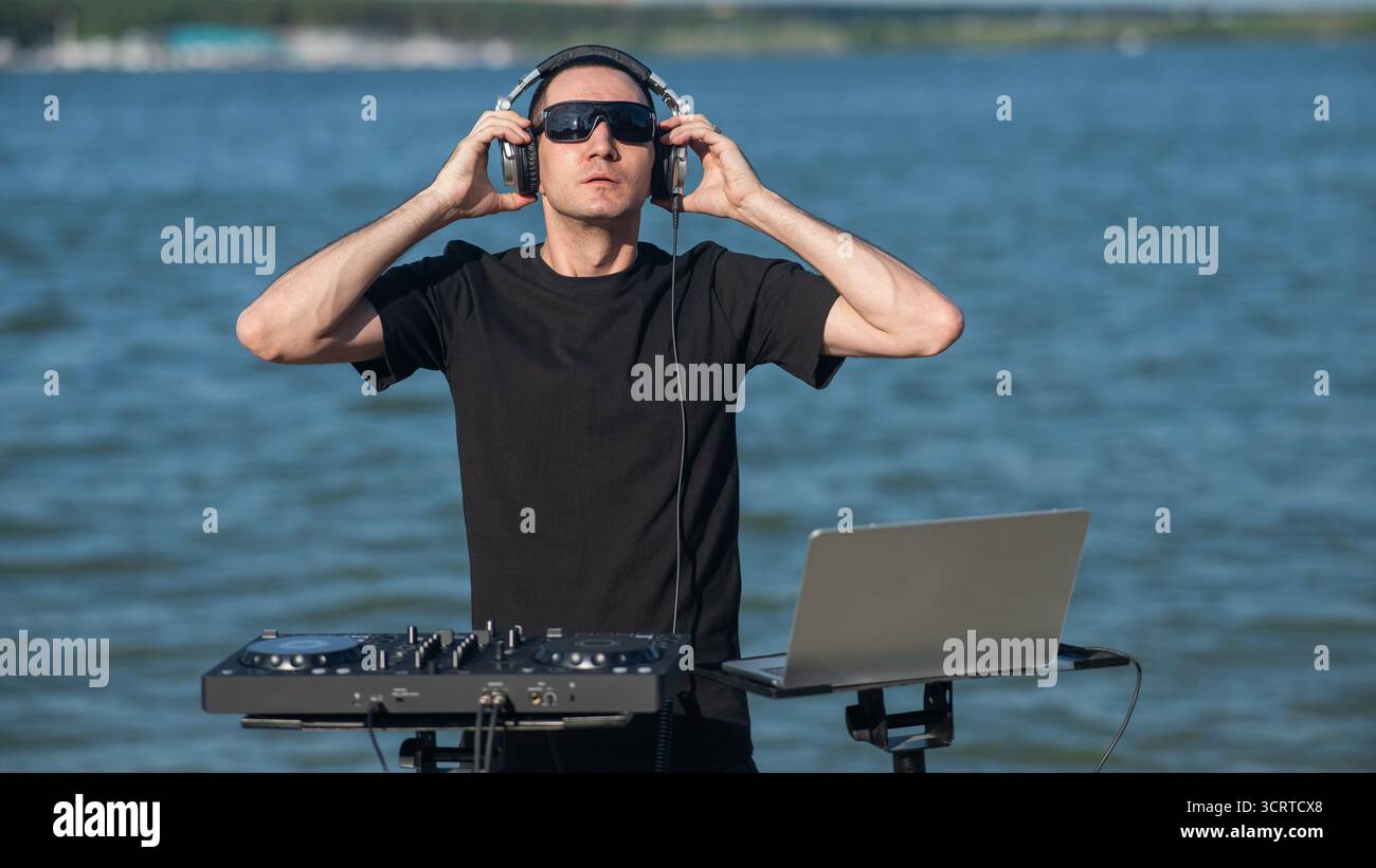 Male DJ playing music on the beach Stock Photo - Alamy