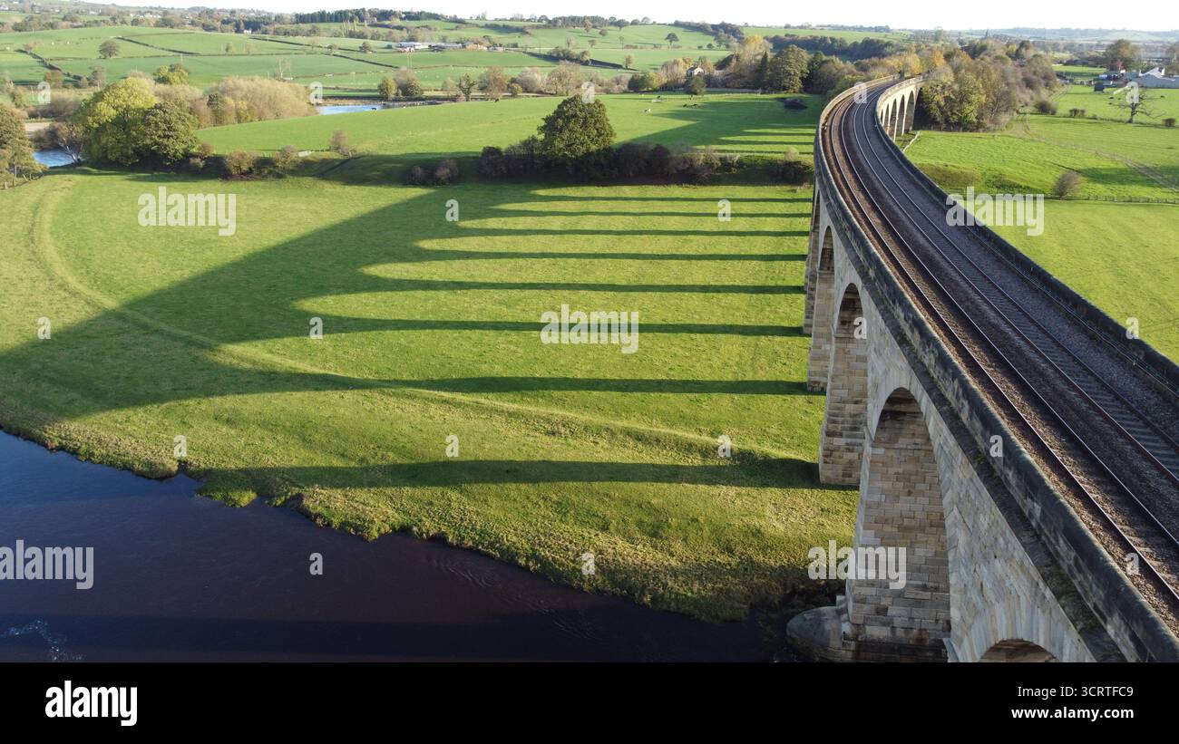 Aerial view of Arthington Viaduct casting long shadows across green ...