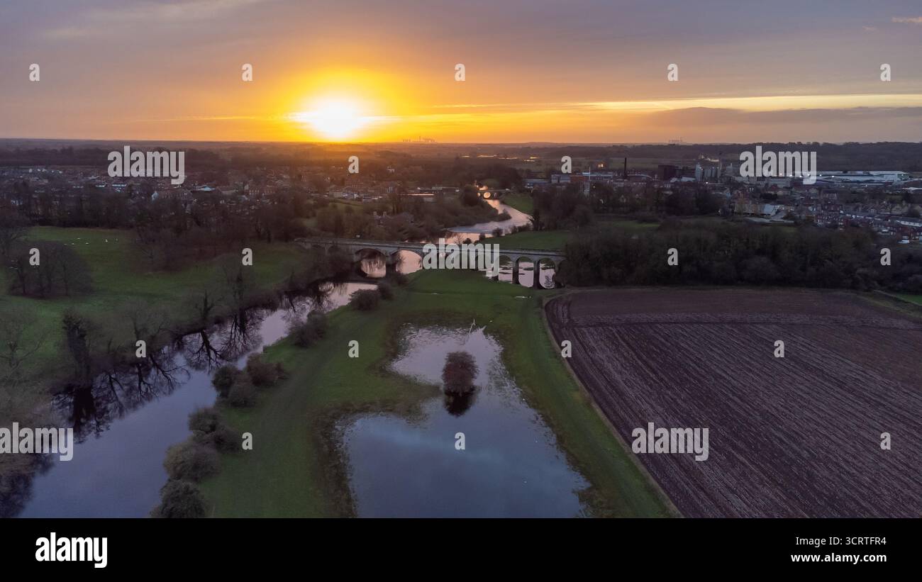 Aerial view of Tadcaster flooding at sunrise with bridge over the River ...