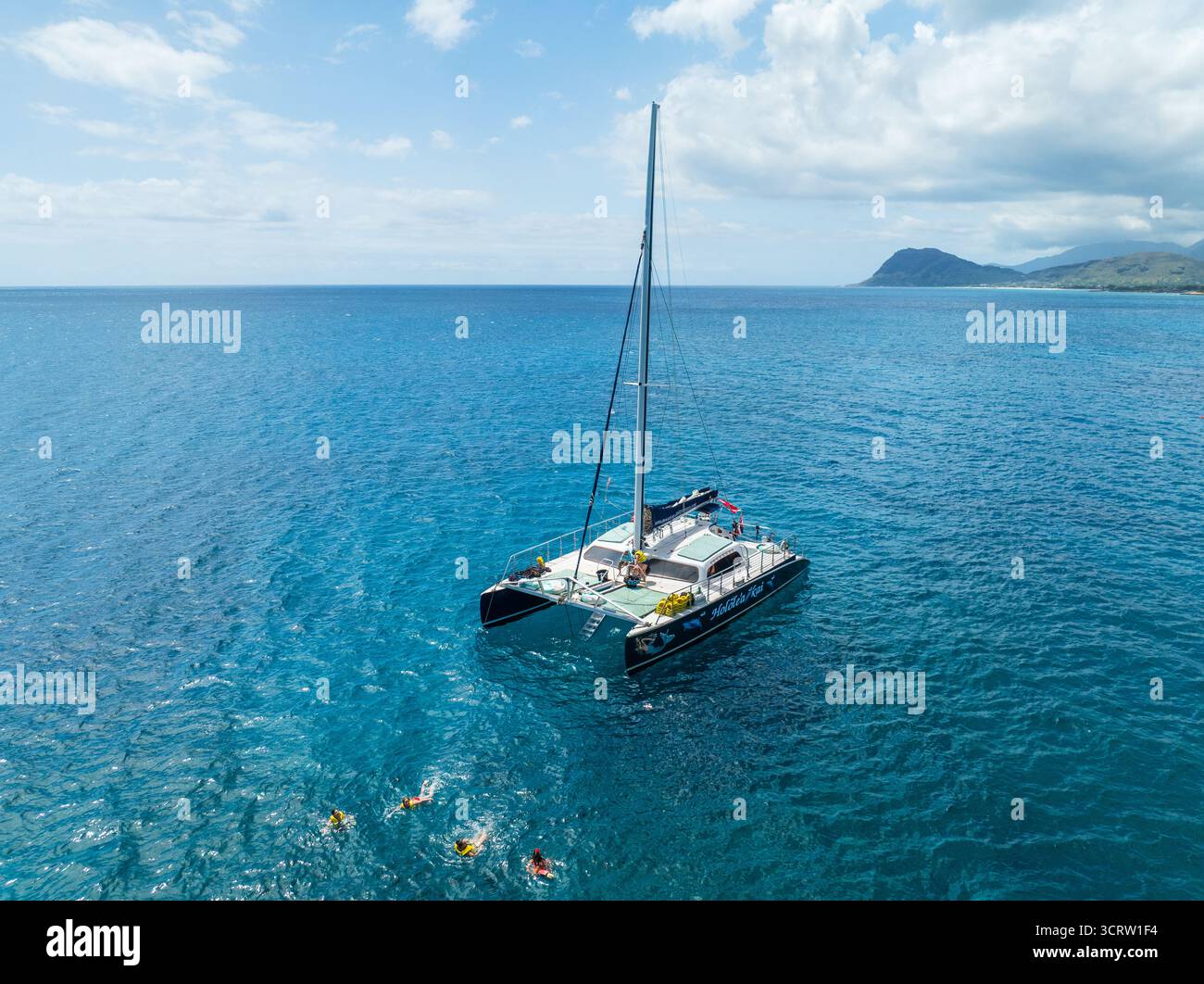 Aerial view of a sleek catamaran cuts through the turquoise waters, as ...