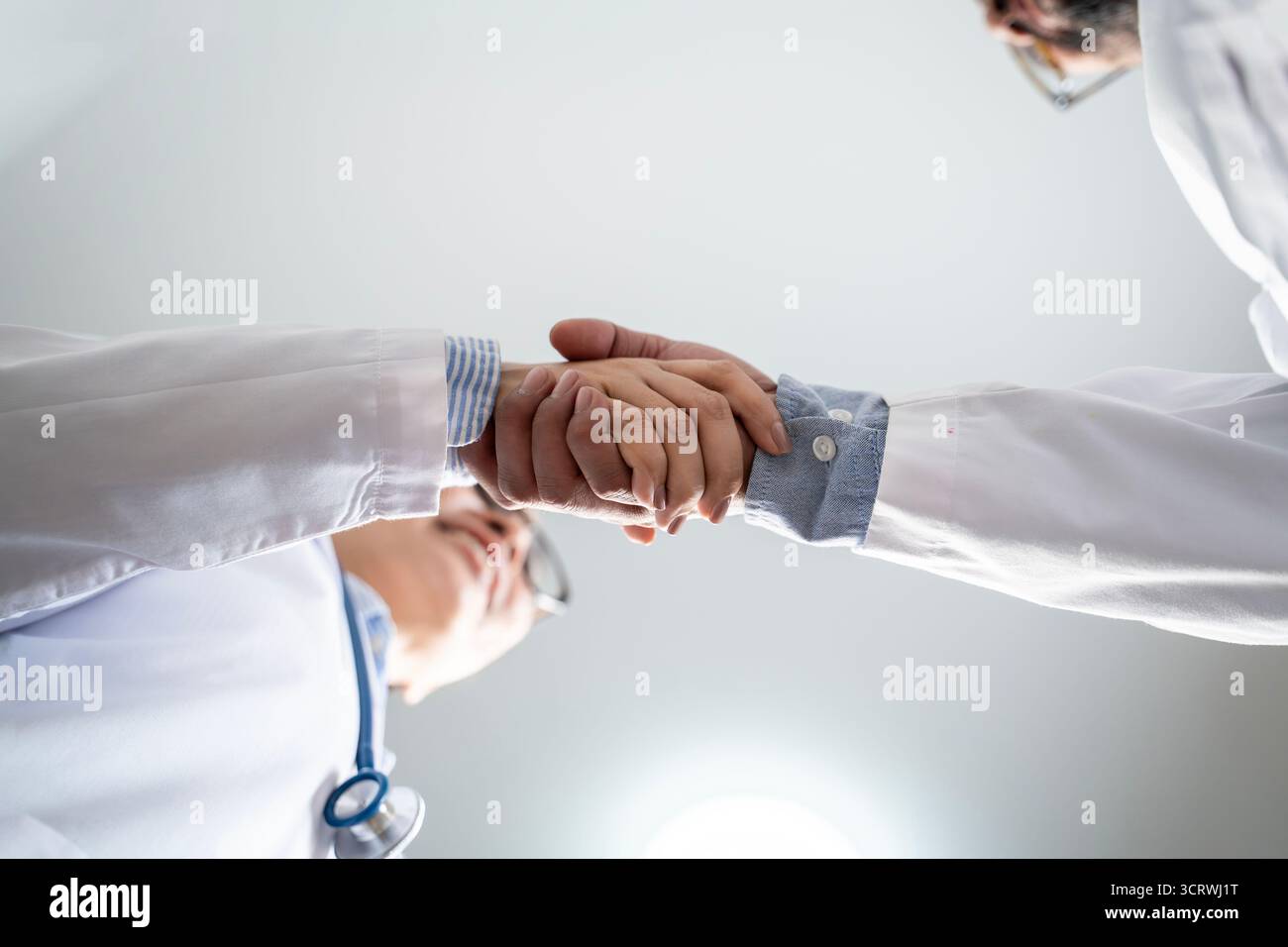Close-up of two doctors shaking hands, concept of healthcare teamwork ...
