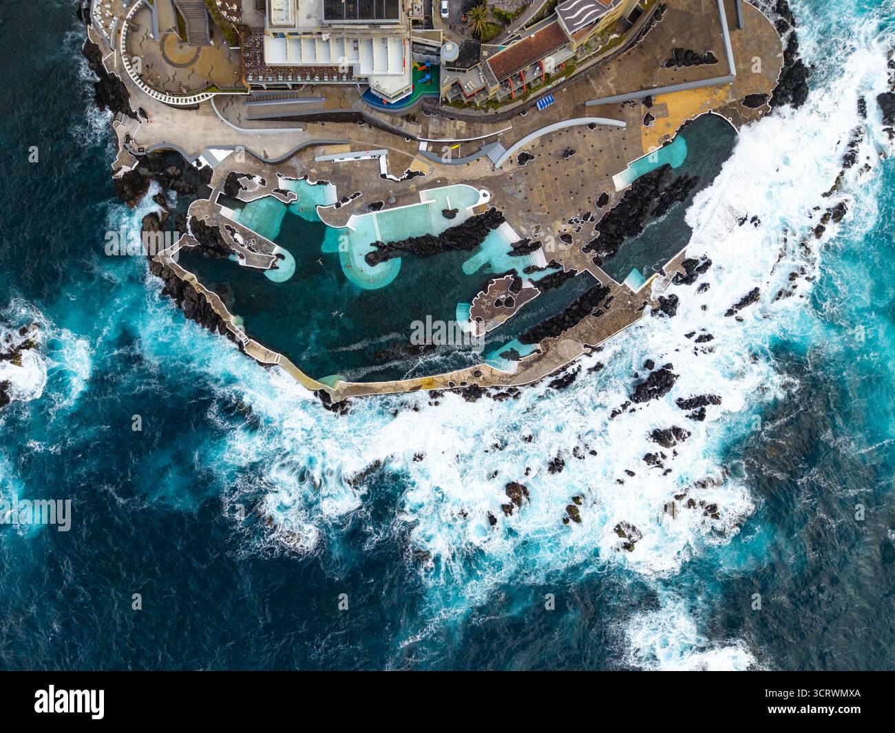 Aerial view of the natural rock pools contrasting with the deep blue ...