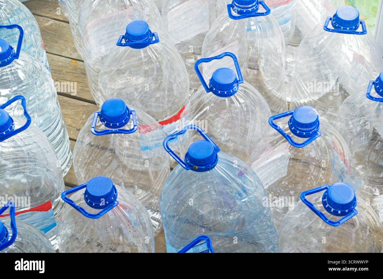 Many empty plastic gallons of drinking water on wooden background Stock ...