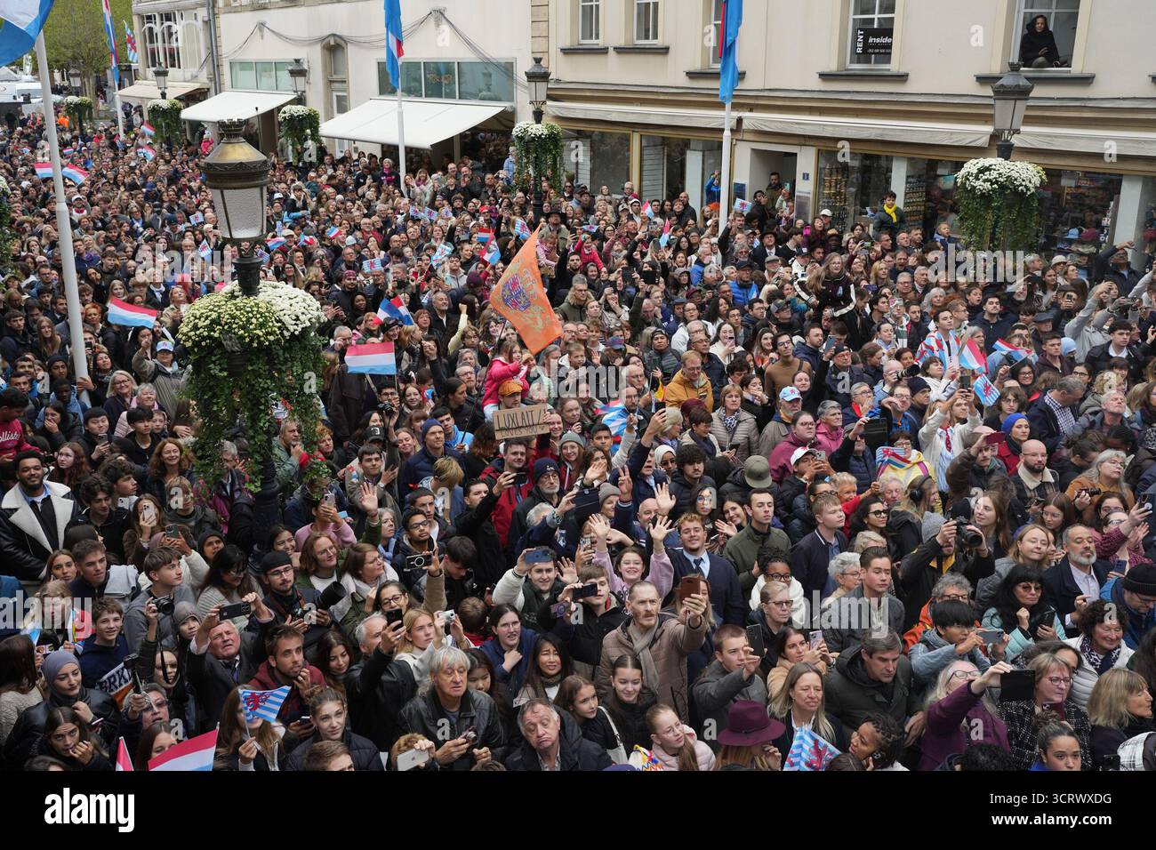 Members of the public wave flags as they stand outside the Grand Ducal ...