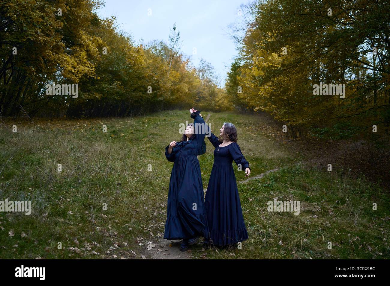 Two women in long black dresses perform a historical reenactment of the ...