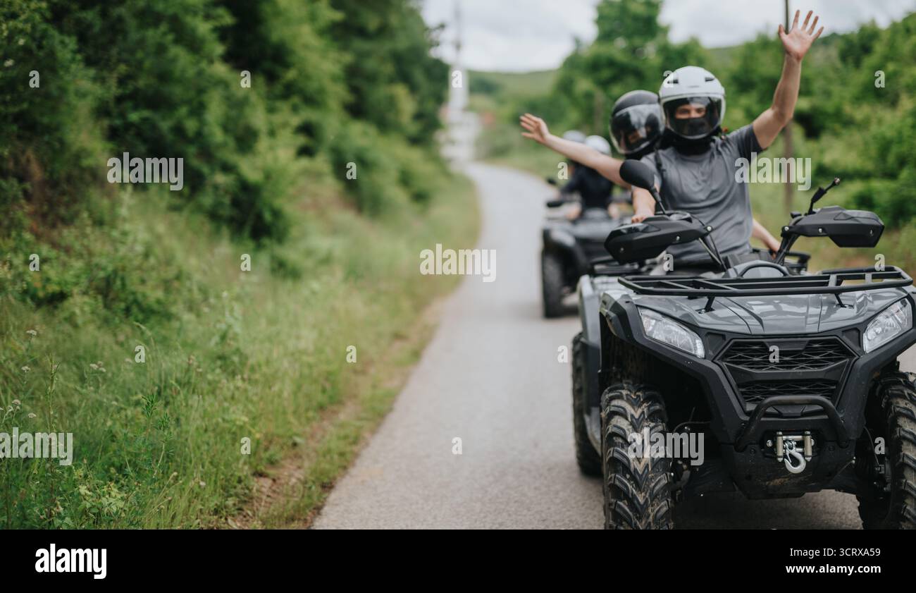 Friends riding quad bikes on scenic countryside road enjoying nature ...