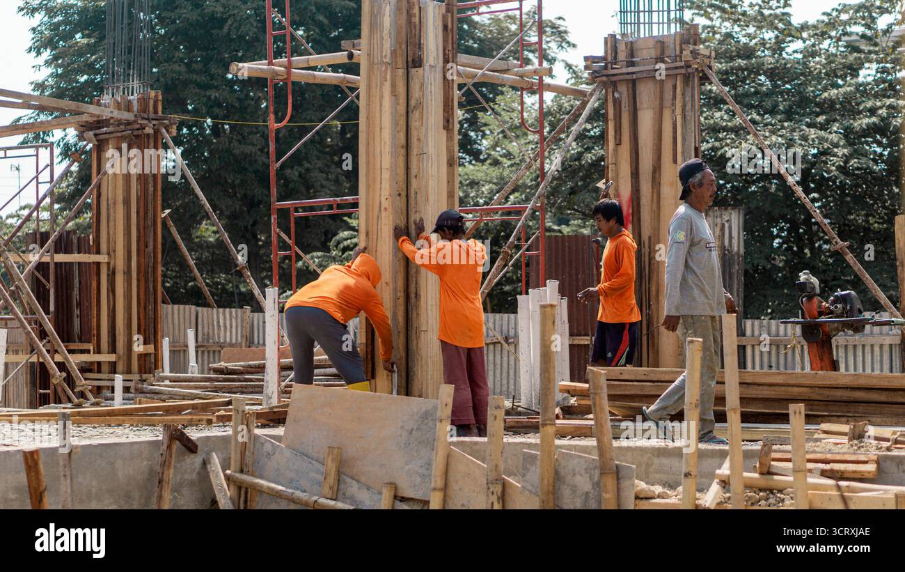 Worker dismantling building formwork boards at construction site ...