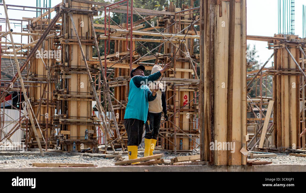 Worker dismantling building formwork boards at construction site ...
