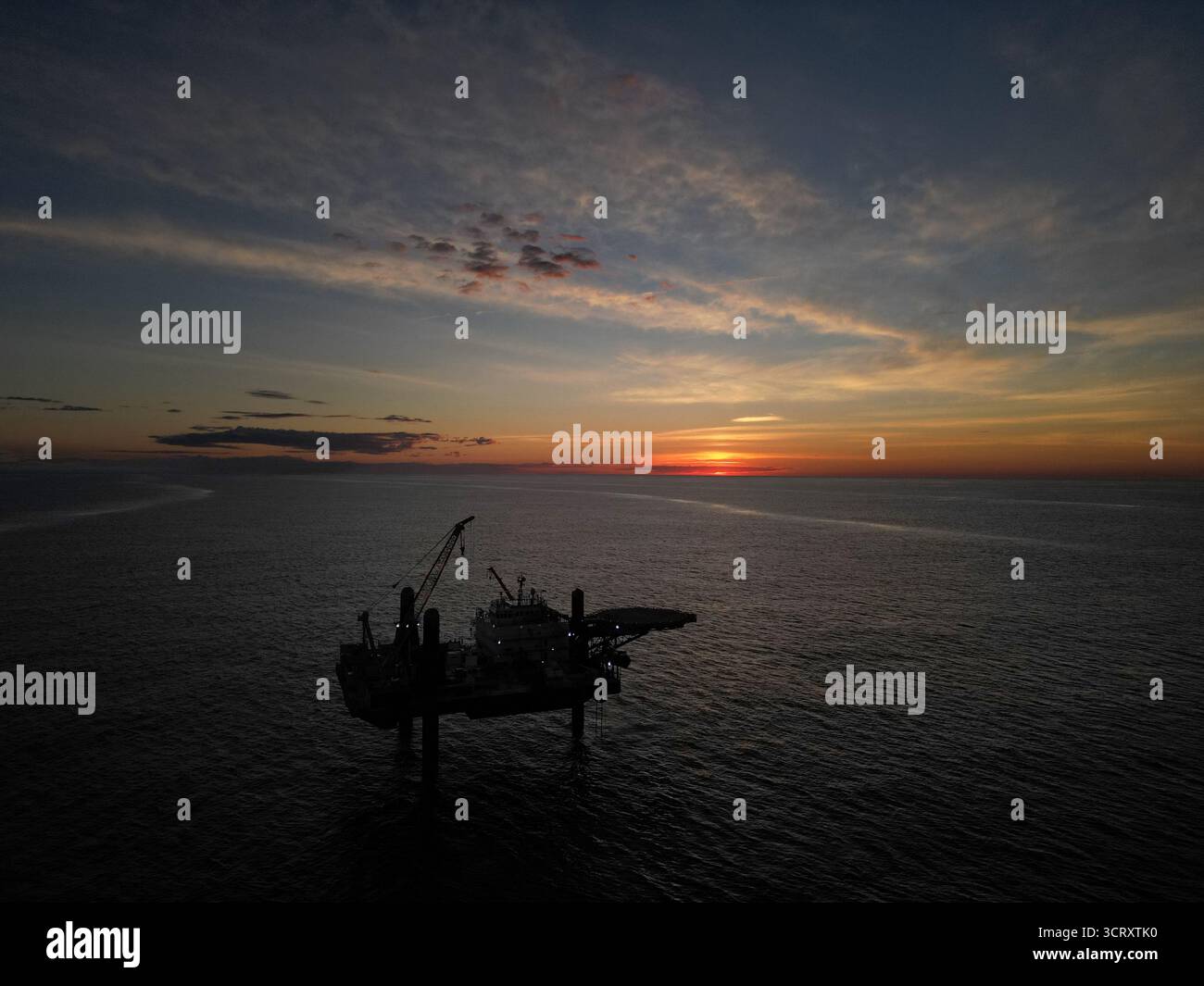 The sun sets behind the Liftboat Robert platform, home of Expedition ...