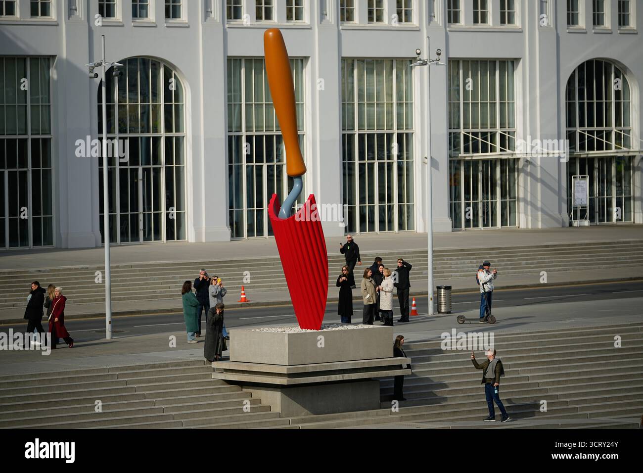 People walk next to Plantoir, a sculpture of a giant garden trowel by ...