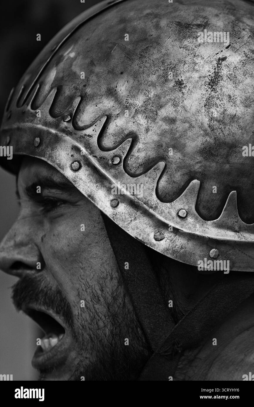 A close-up of a man in medieval armor screaming with intensity during a ...