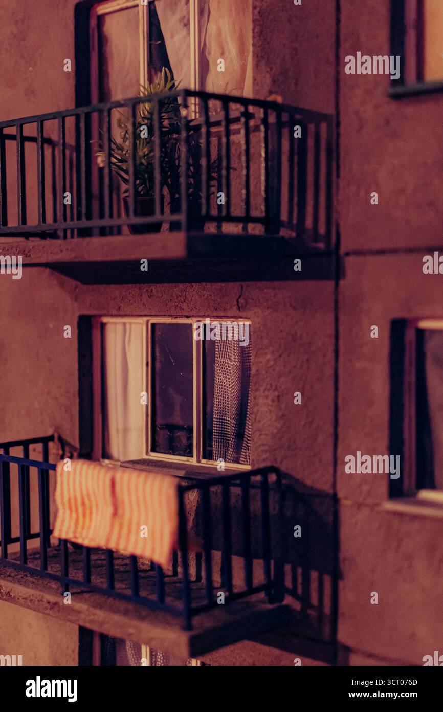 Close-up of a weathered apartment balcony at night, with dim light ...