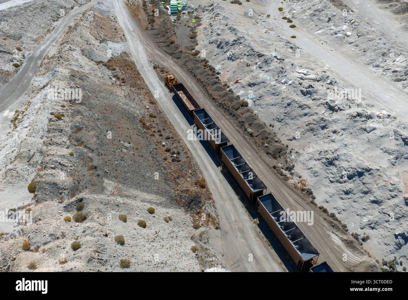Aerial view of a salt mining site in Nevada featuring a train on a dirt ...