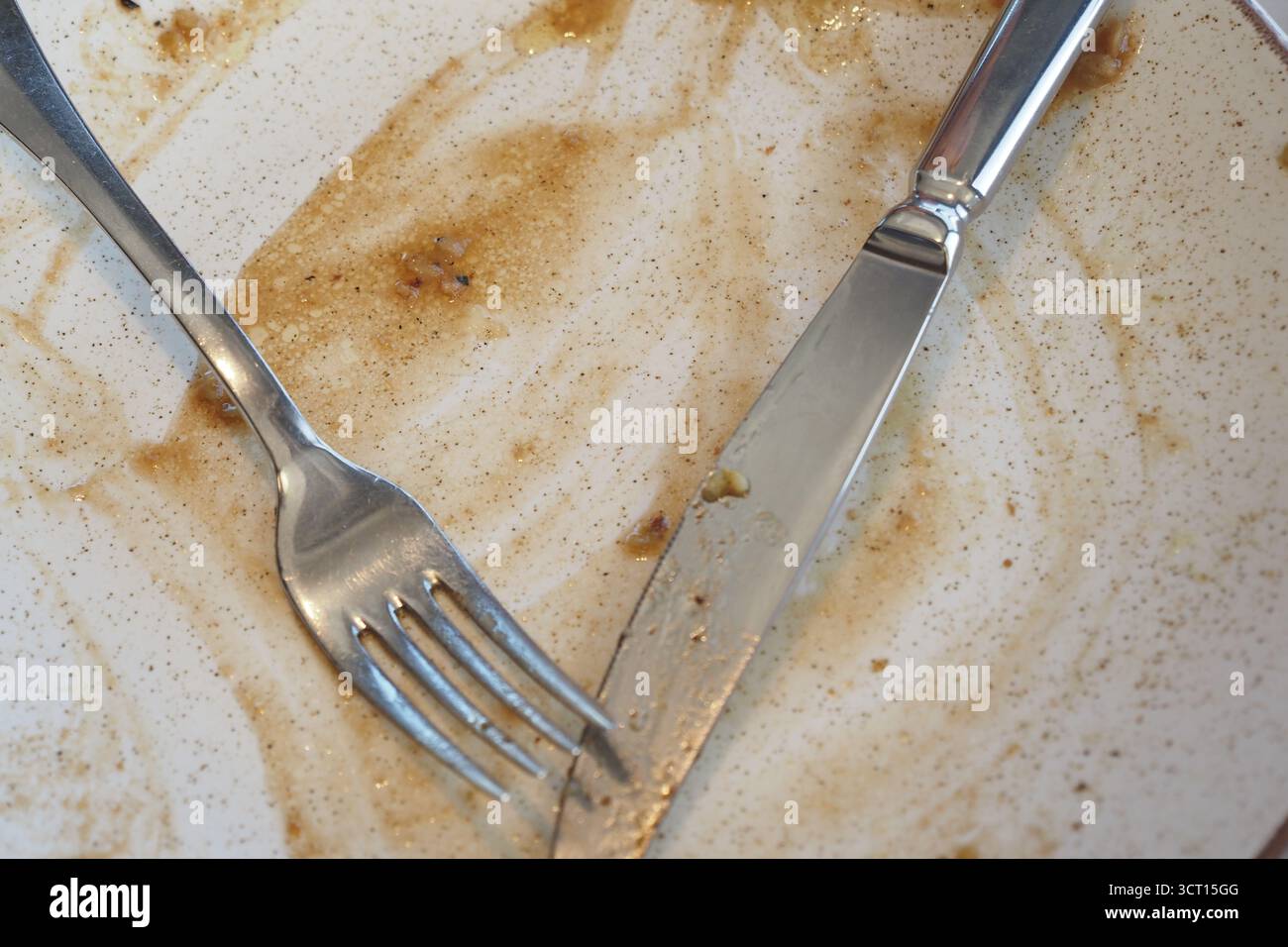 Empty plate with fork and knife after a meal in a restaurant Stock ...
