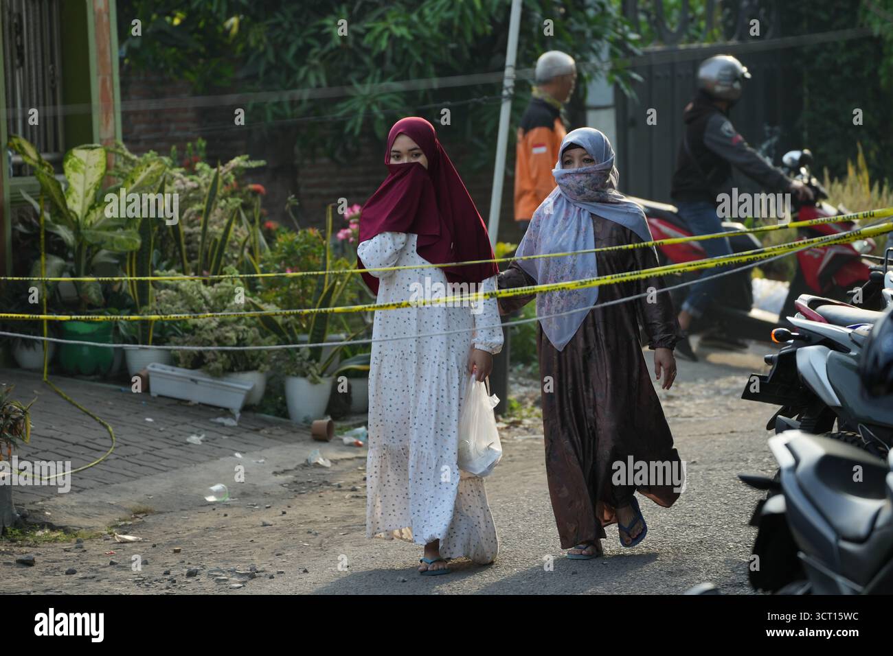 Women walk near the Islamic boarding school compound where a building ...