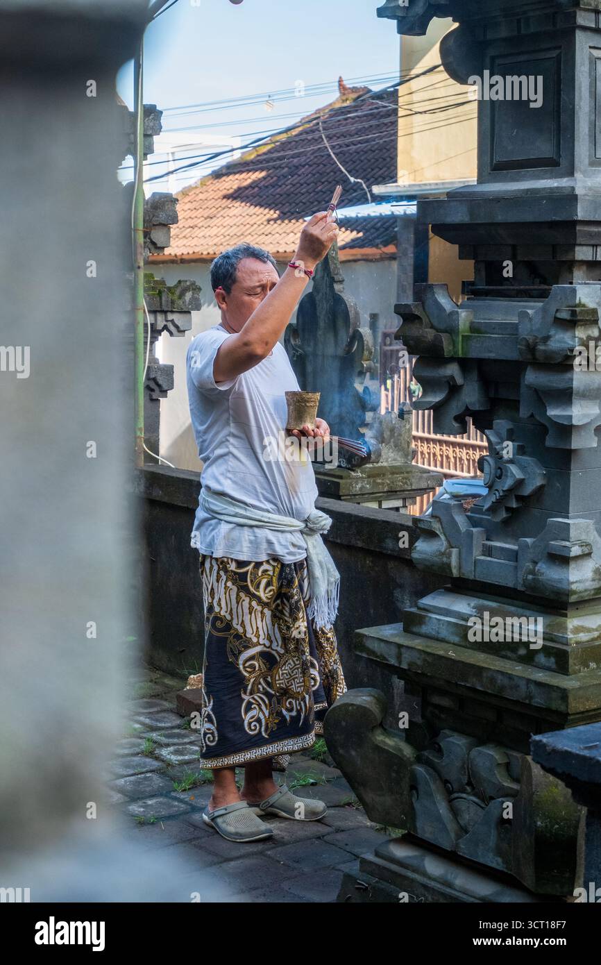 Balinese people are performing prayers or rituals at a temple in the ...