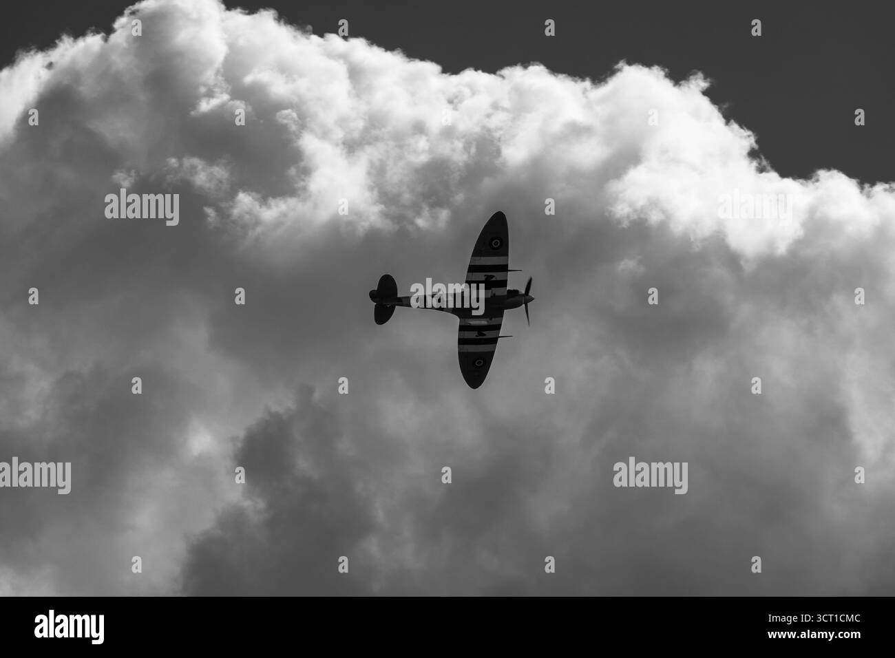 Monochrome view of World War Two Spitfire in flight beneath striking ...