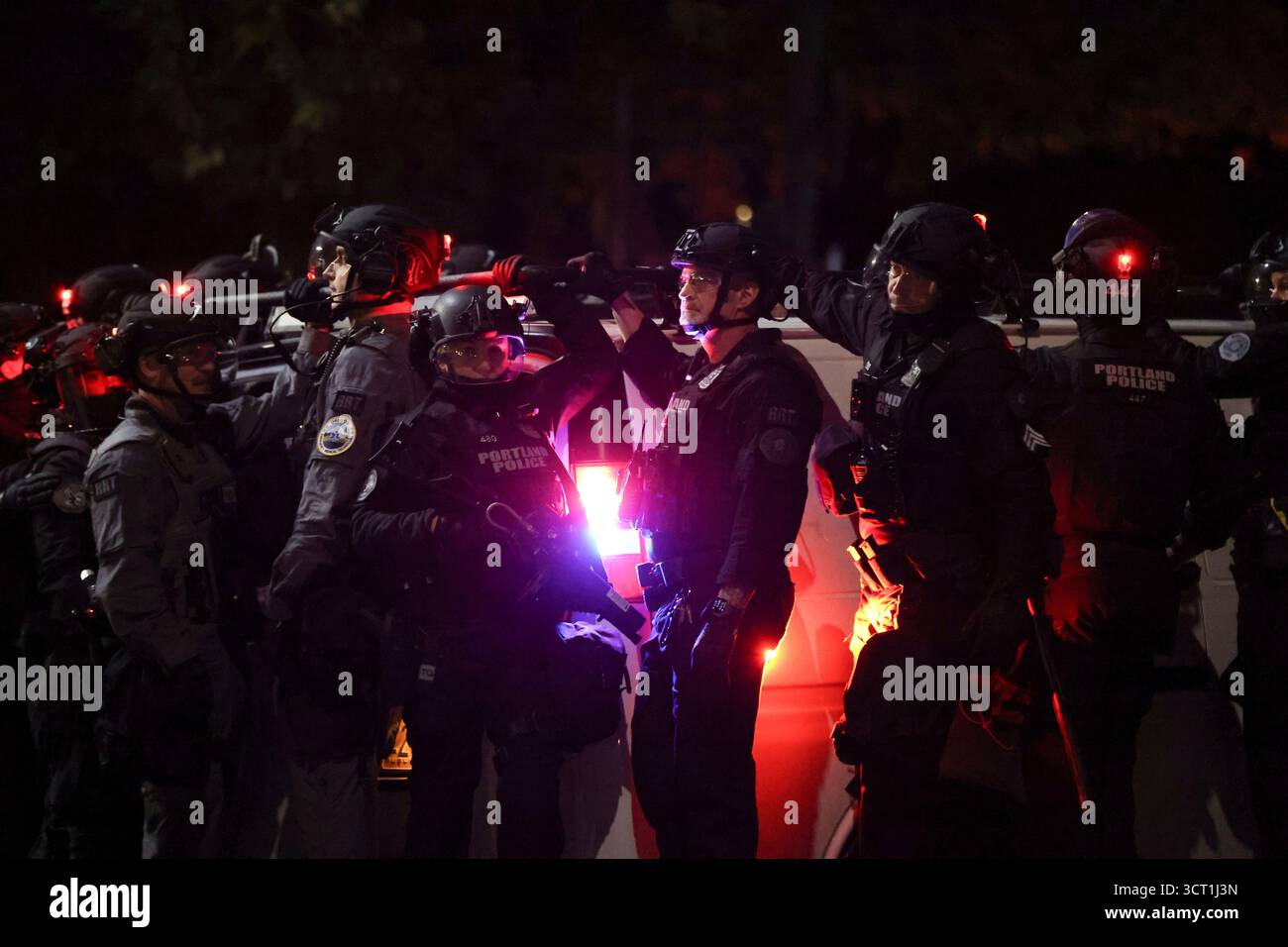 Portland Police load onto a van as people protest outside a U.S ...