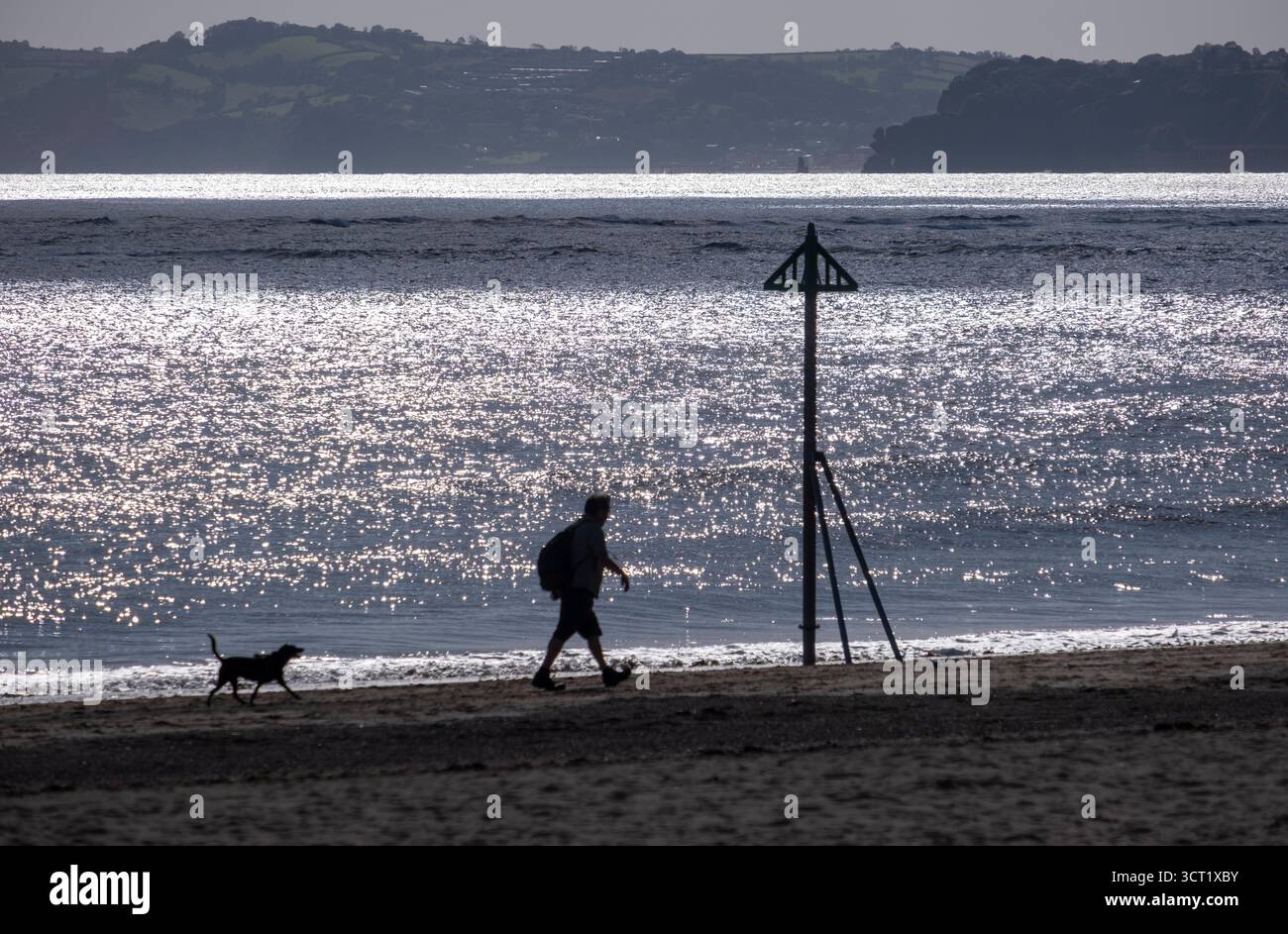 Sunlight reflects of the ocean and creates silhouetted figures on the ...